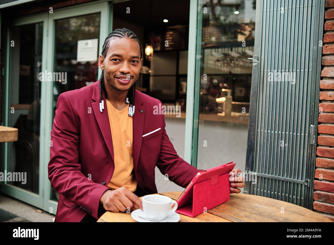 African man drinking a coffee while using a tablet Stock Photo - Alamy