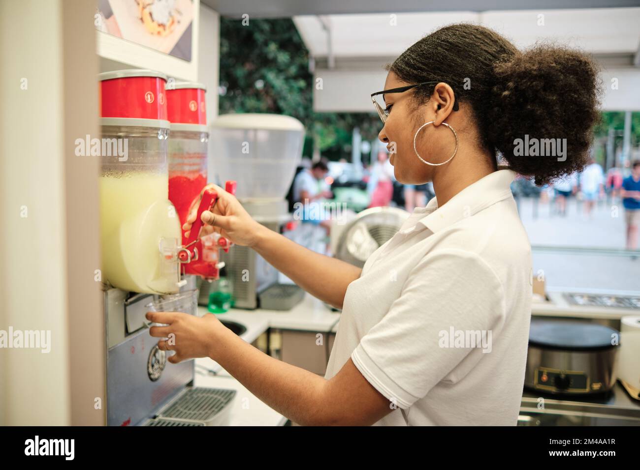 Shop assistant in a cafeteria using a drink dispenser Stock Photo - Alamy