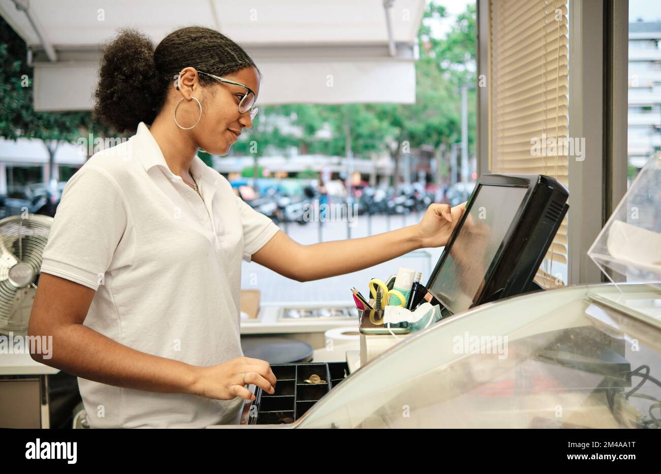 Profile of a cafeteria worker using the cash register Stock Photo - Alamy