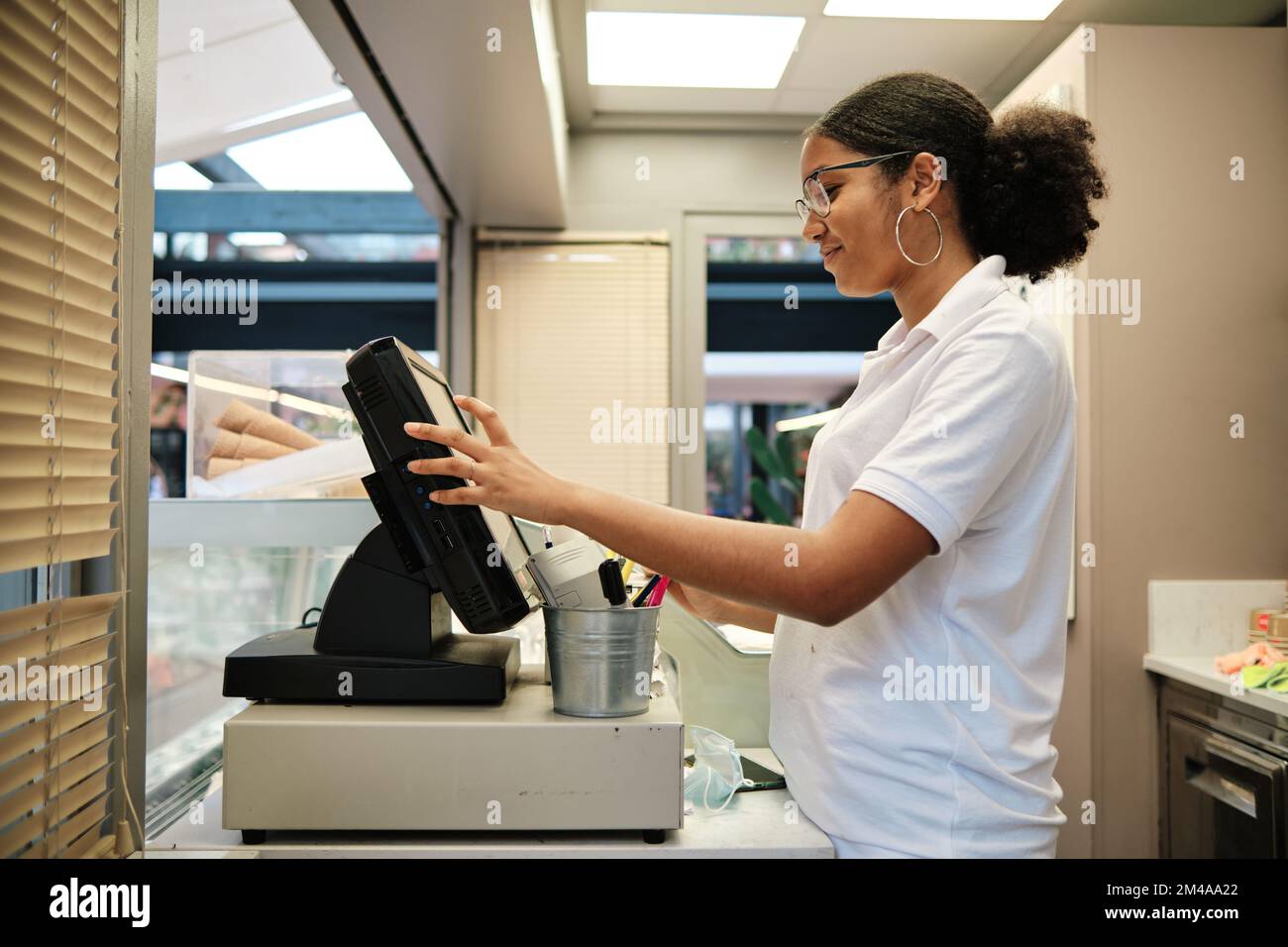 African worker using the cash register in a cafeteria Stock Photo - Alamy