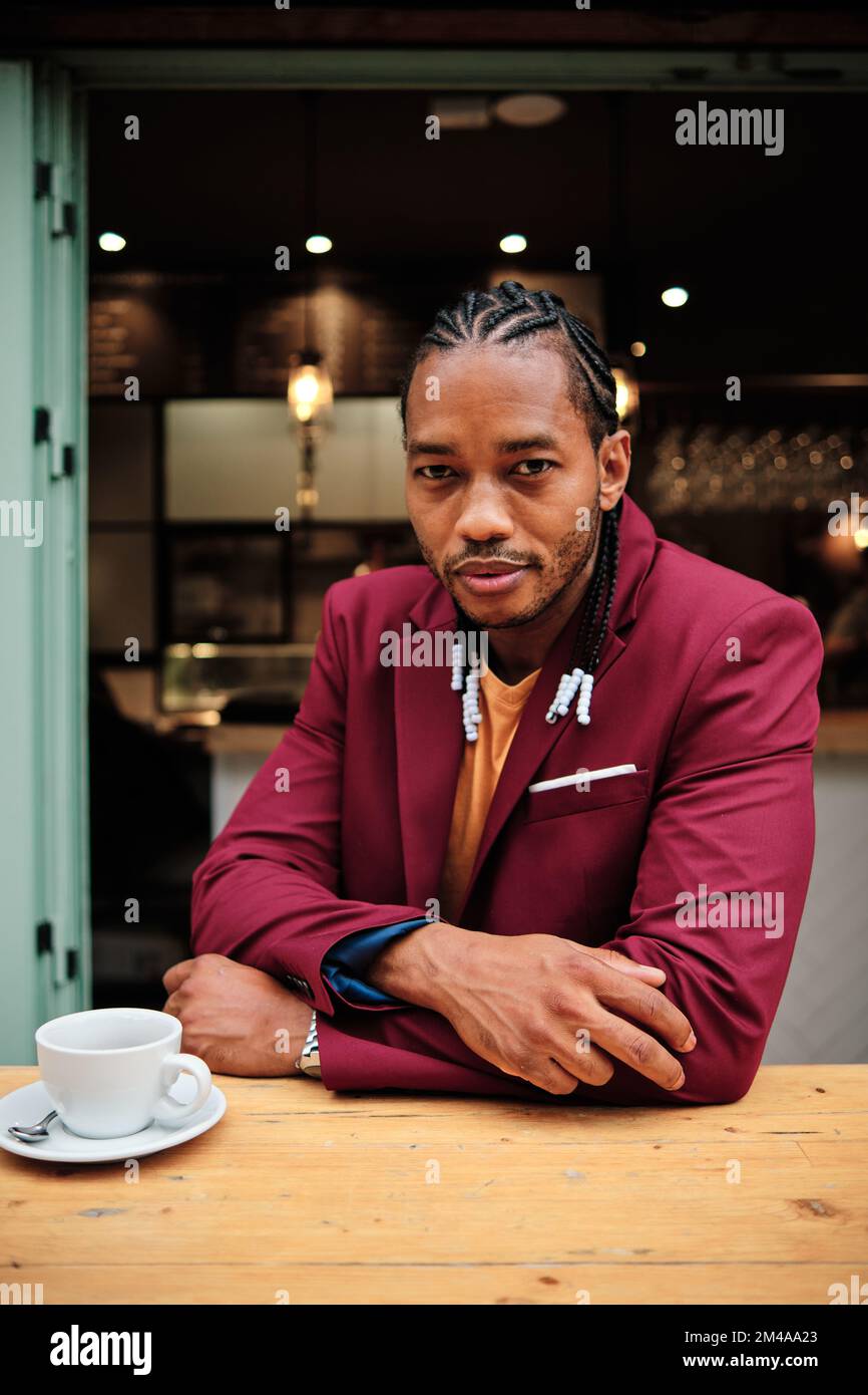 Vertical portrait of an african man sitting in a cafeteria Stock Photo ...