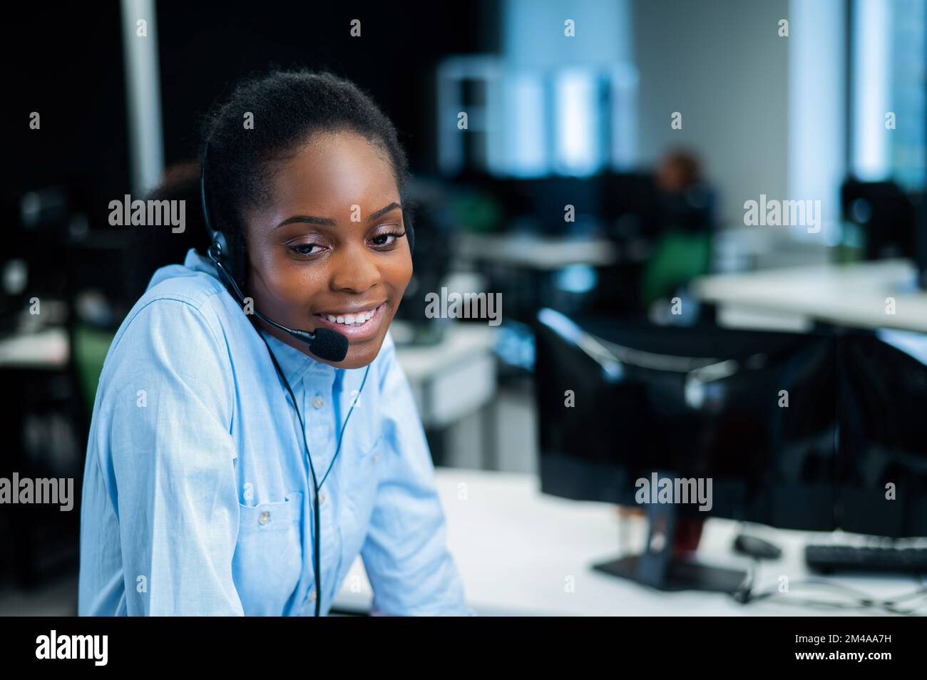 African young woman talking to a client on a headset. Female employee of the call center Stock ...