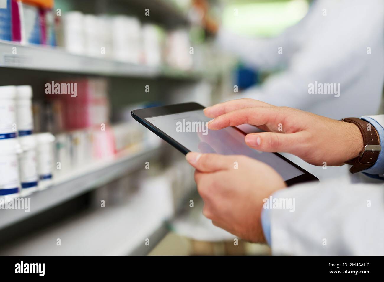 Less paper, more efficient drug store management. a pharmacist using a ...