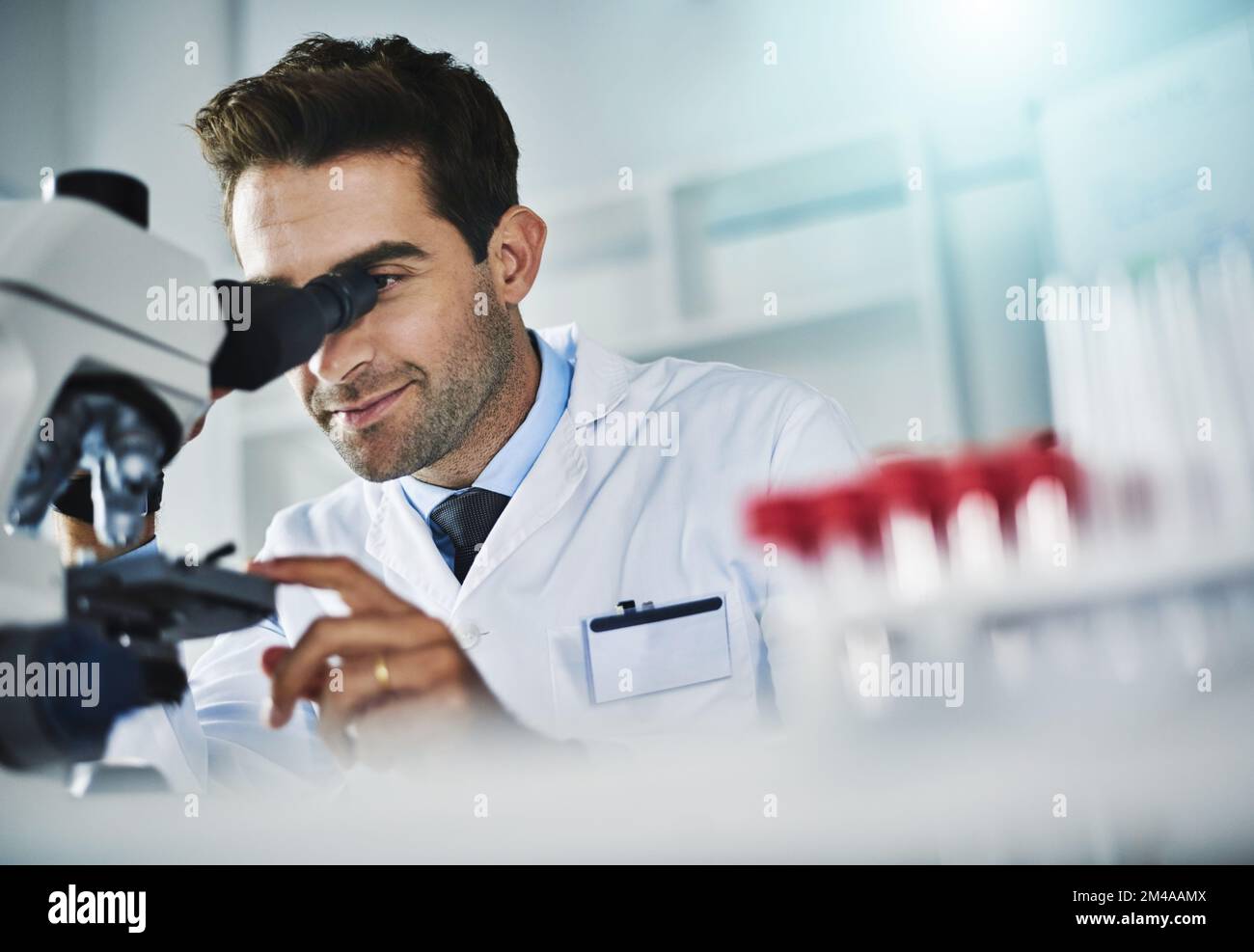 Hell find all the answers. a scientist using a microscope in a lab ...