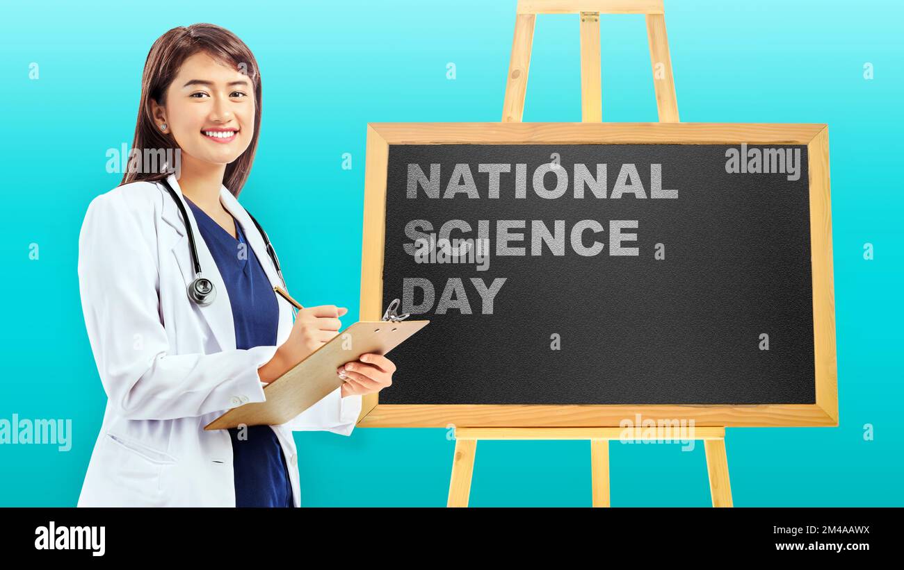 Asian scientists holding a clipboard with National Science Day text on ...