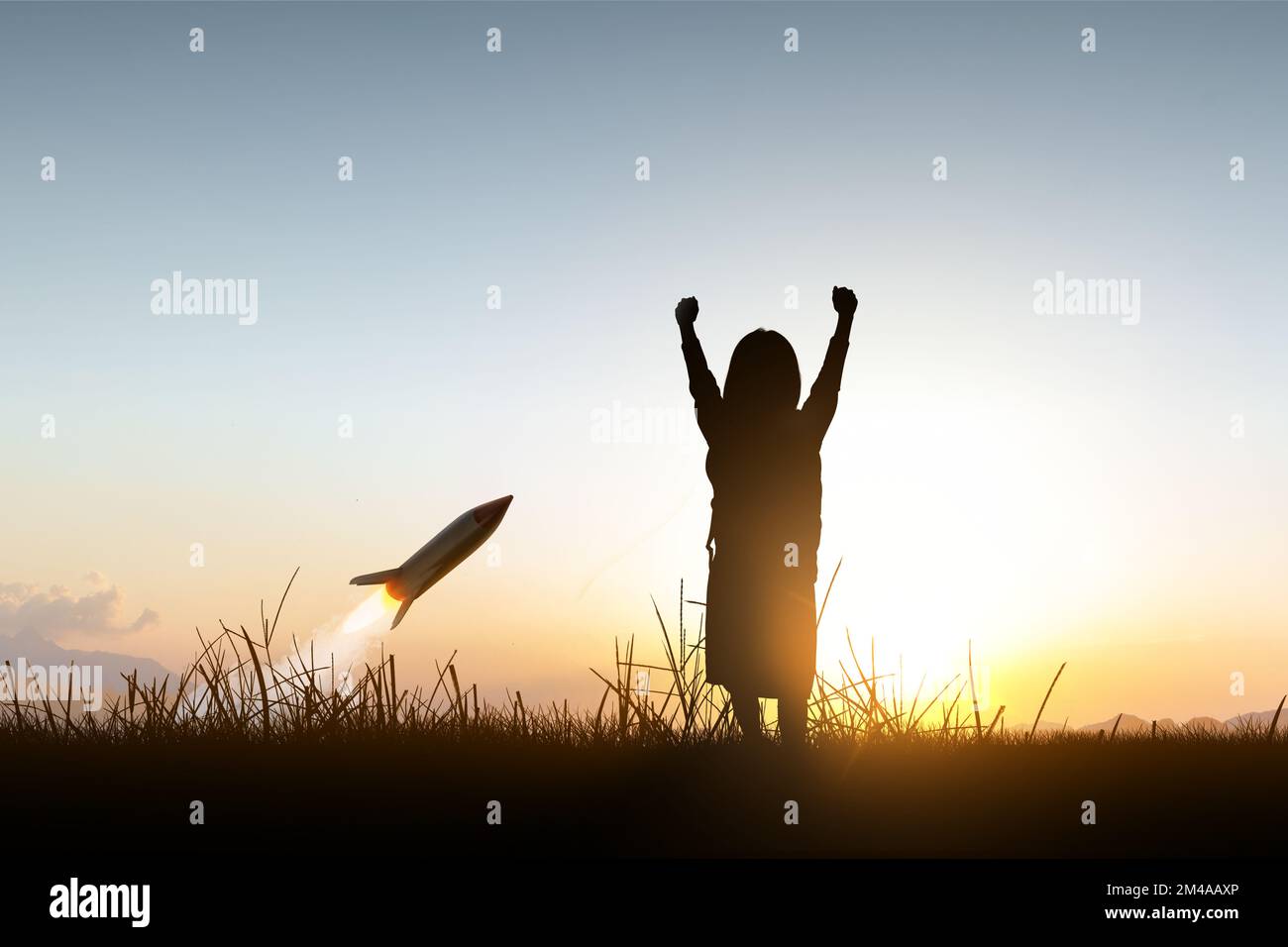 Silhouette of a little girl with rockets flying on the field with a ...