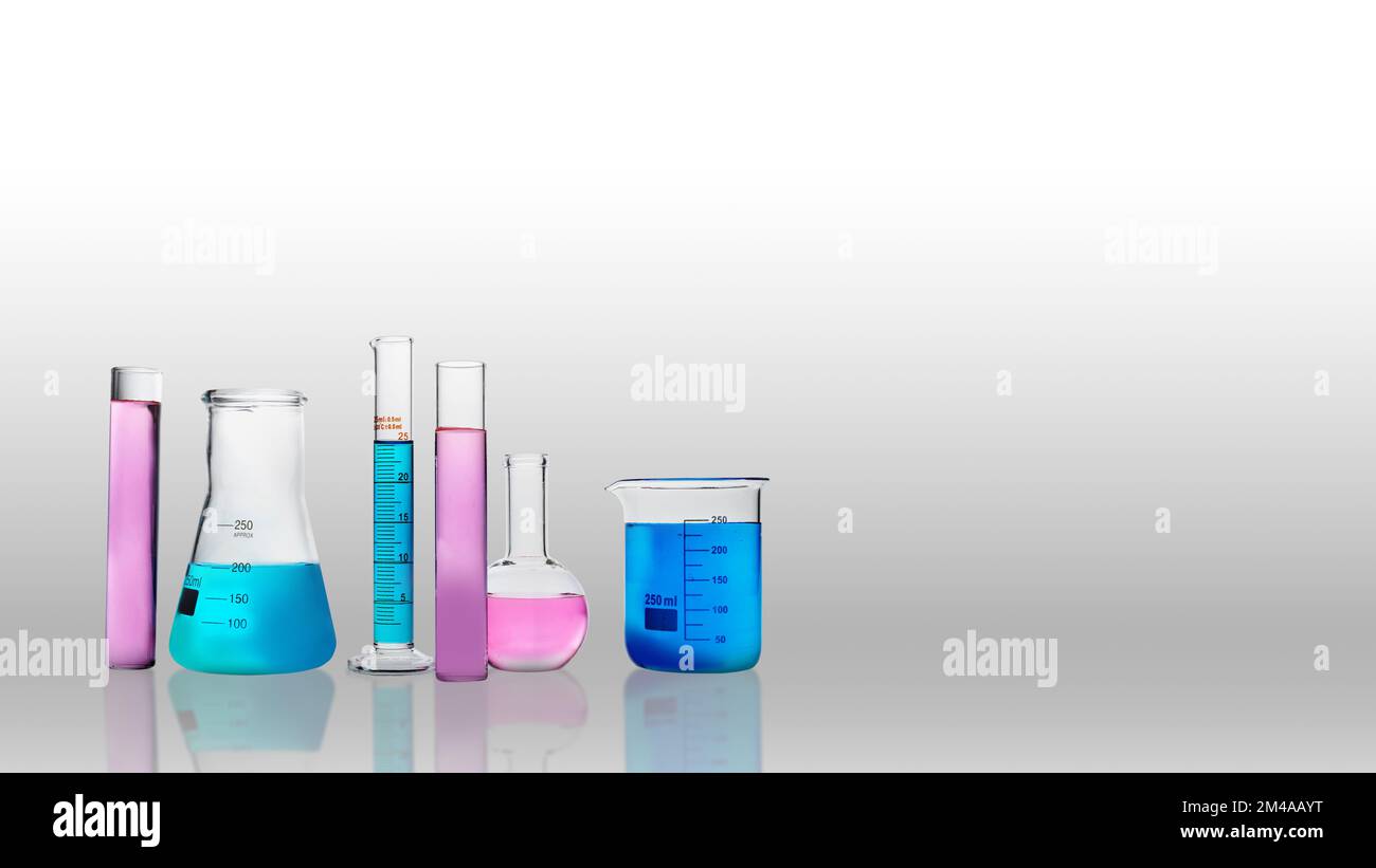 Colorful chemicals in laboratory glassware on a colored background ...