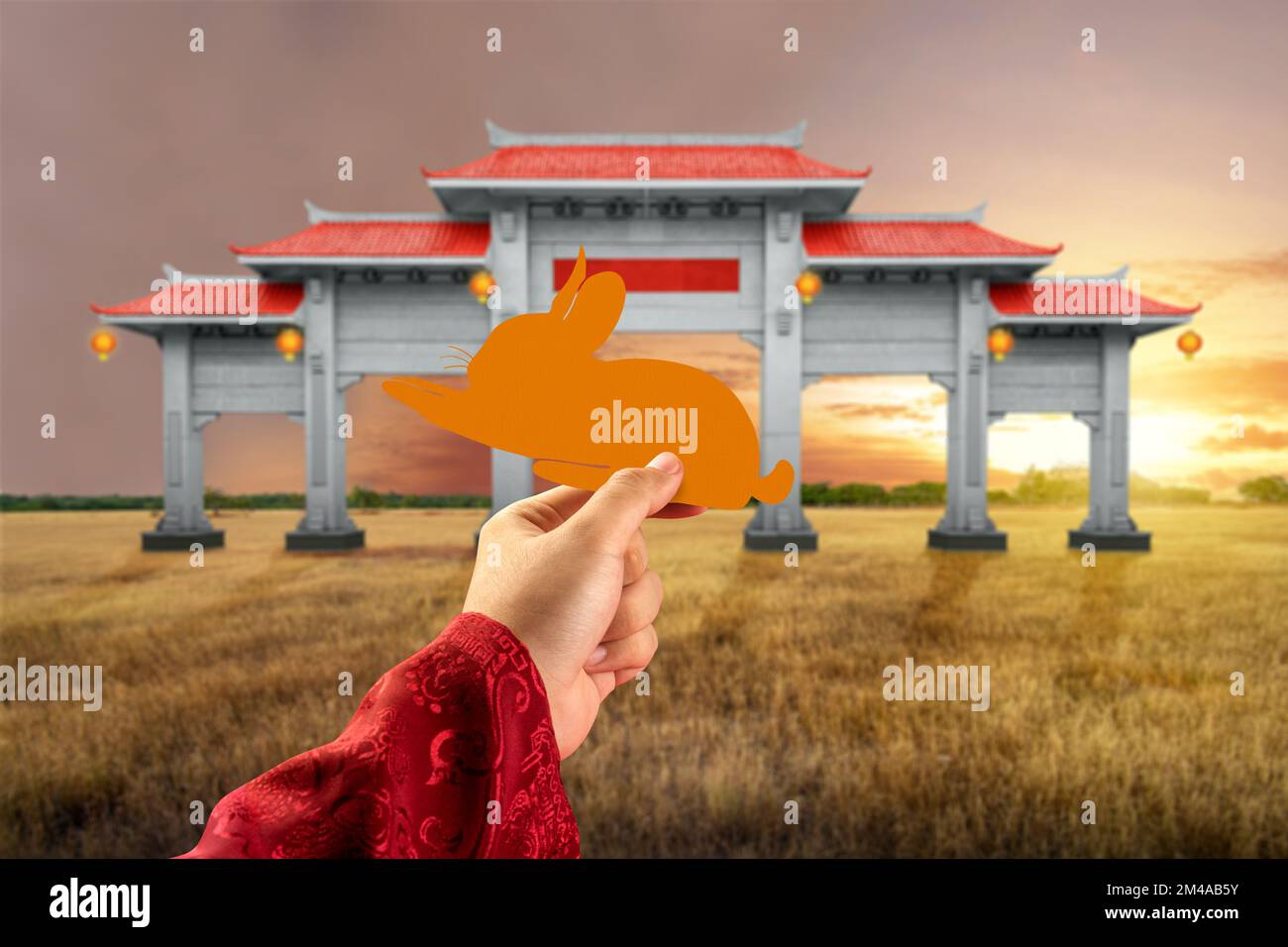 Rabbit on the field with Chinese pavilion gate with red roof and sunset ...
