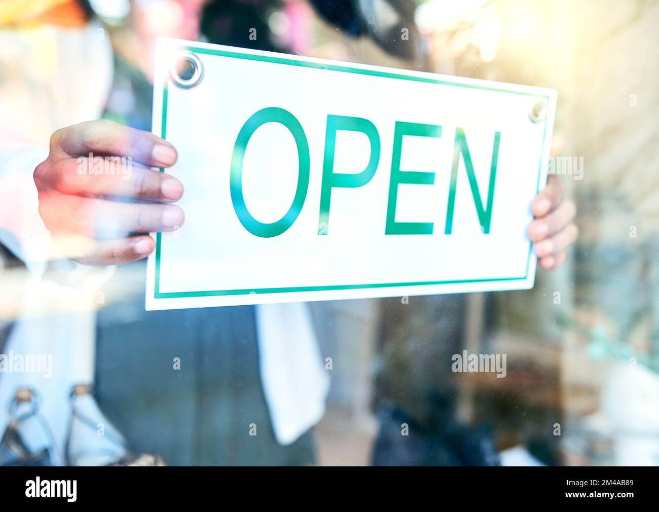 Open for business. an unrecognizable woman holding up an open sign ...