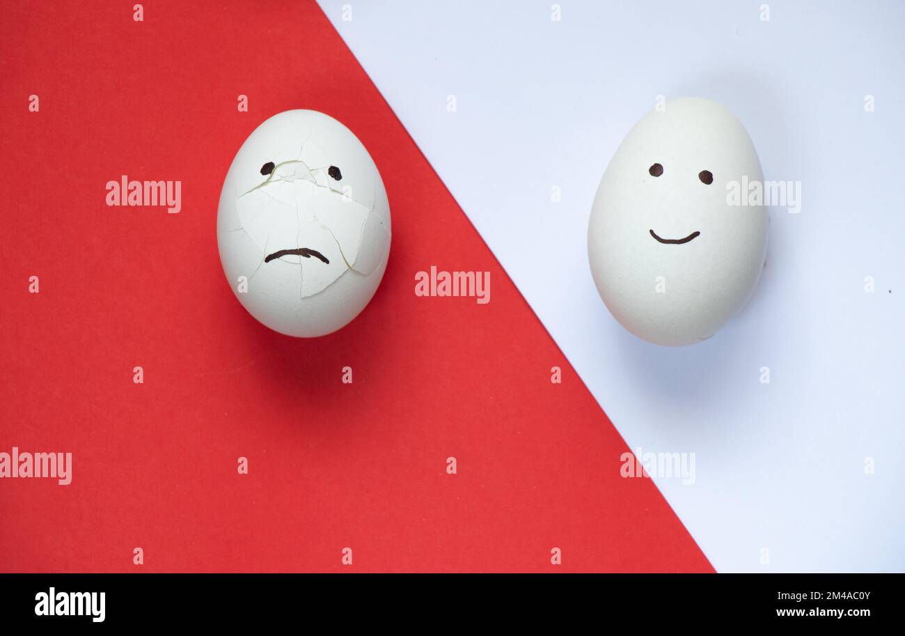 sad and joyful chicken egg on a colored background Stock Photo - Alamy