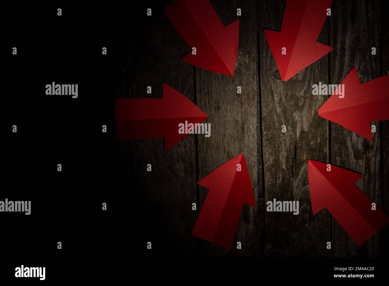 paper arrows pointing to the center of the table on a dark background ...