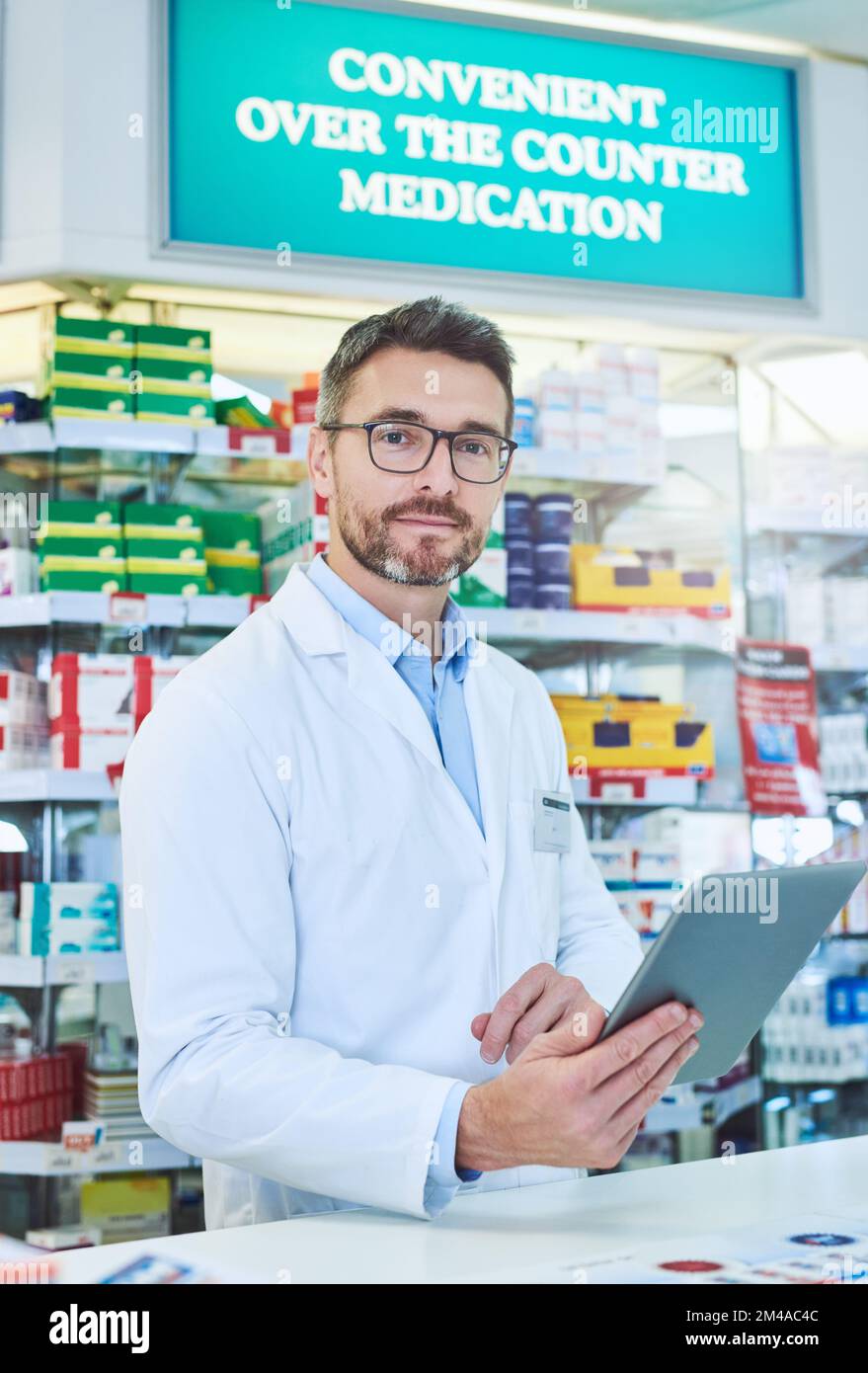 We now fill electronic prescriptions. a mature pharmacist using a ...