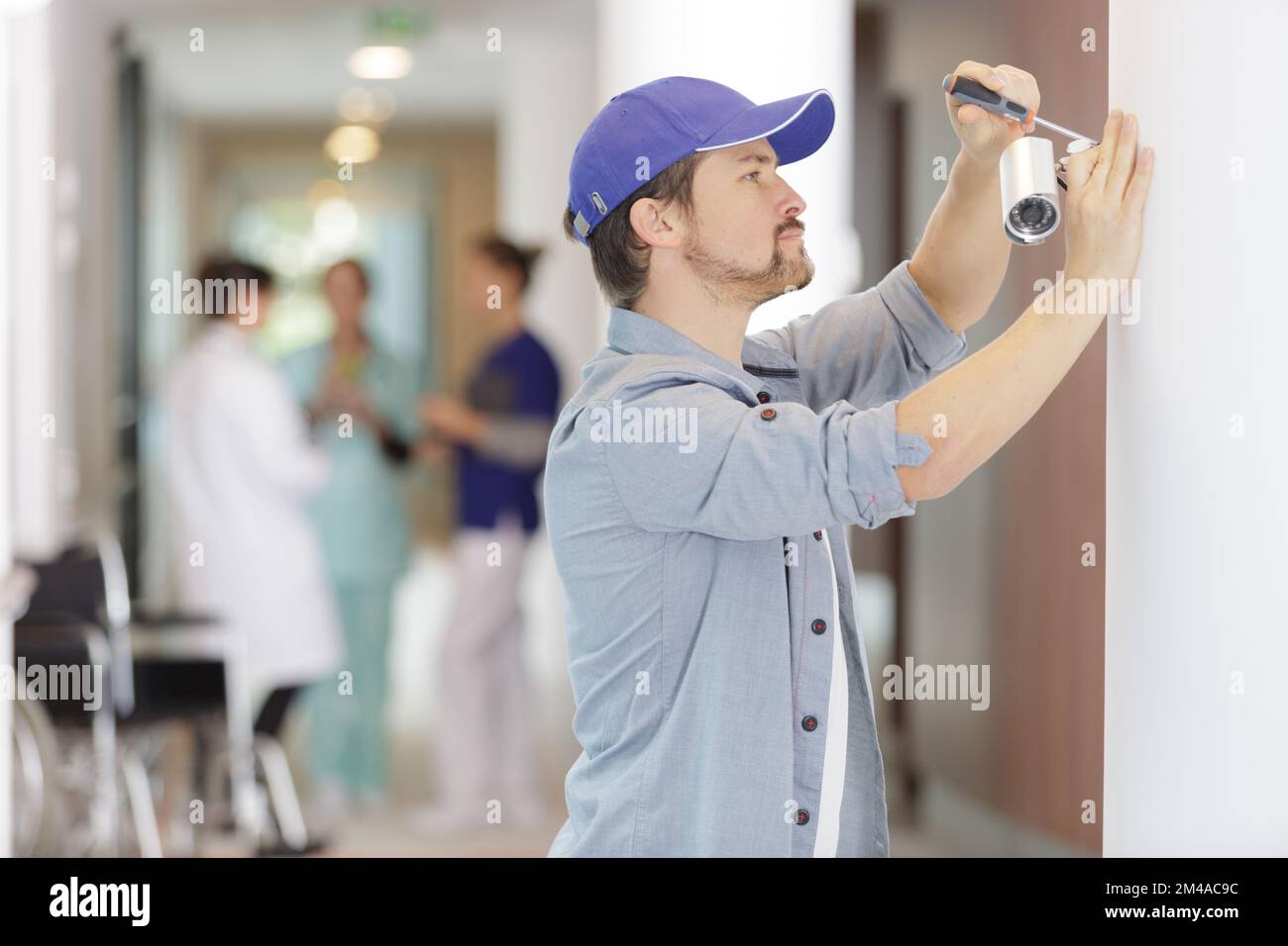young worker repairing door at the hospital Stock Photo - Alamy
