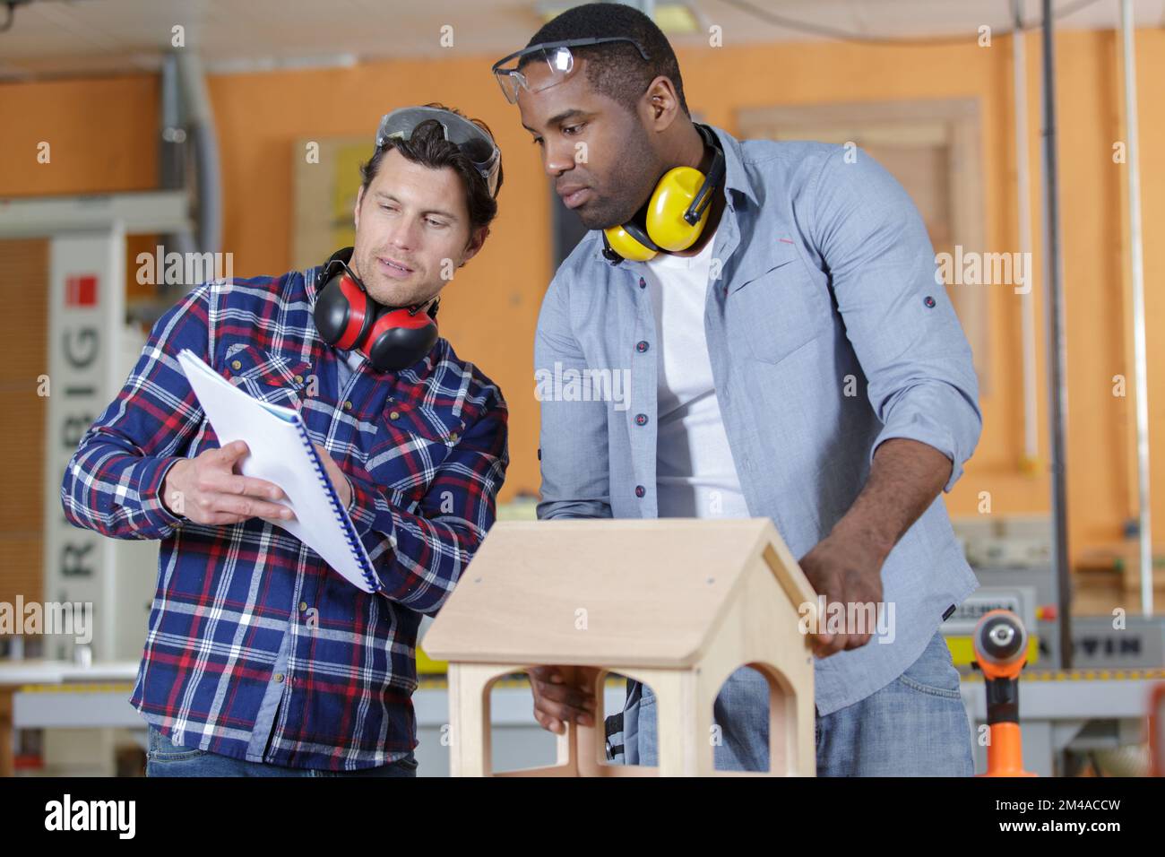 worker with apprentice on a wood house Stock Photo - Alamy
