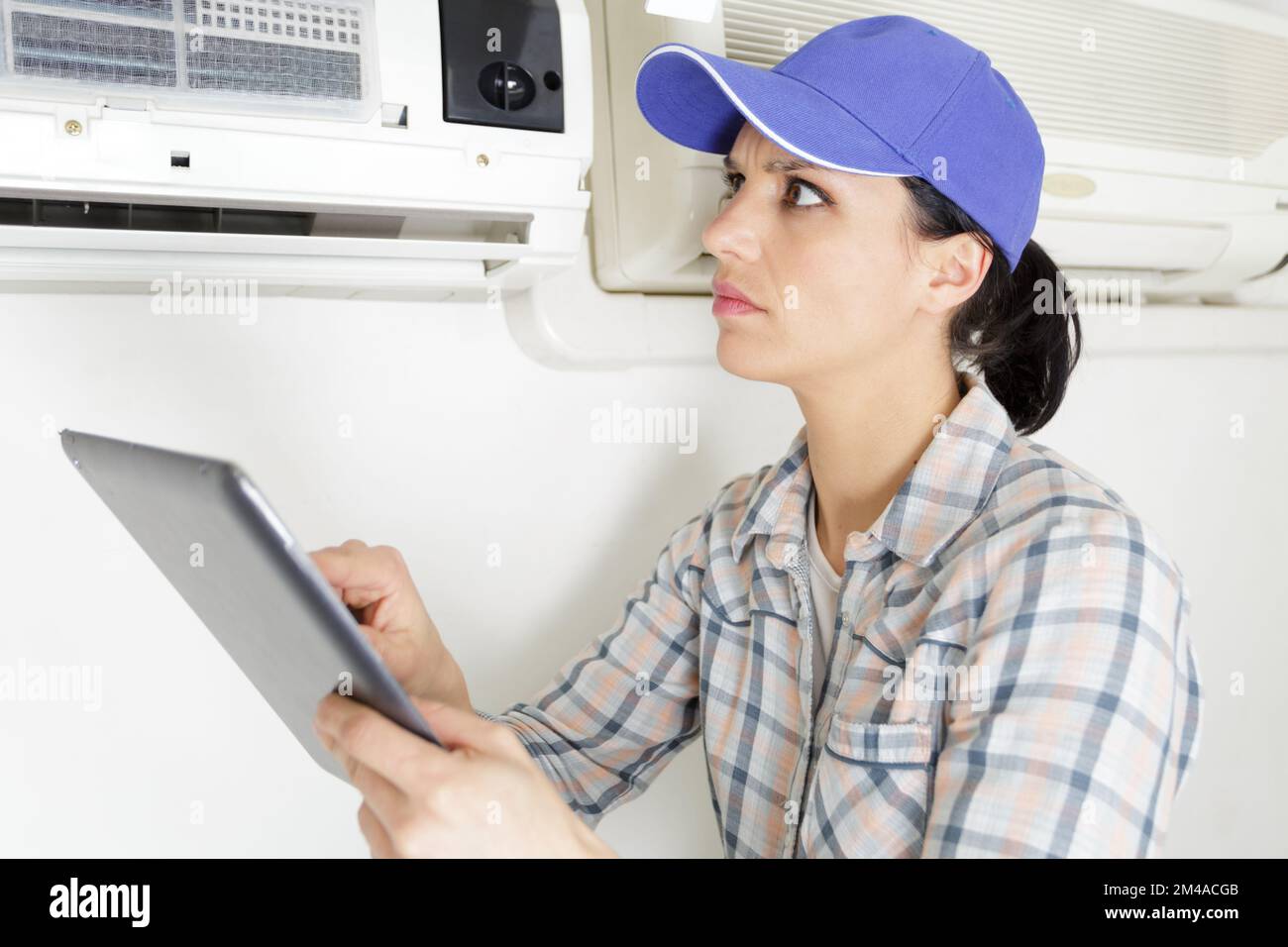 woman checking air conditioning unit Stock Photo - Alamy