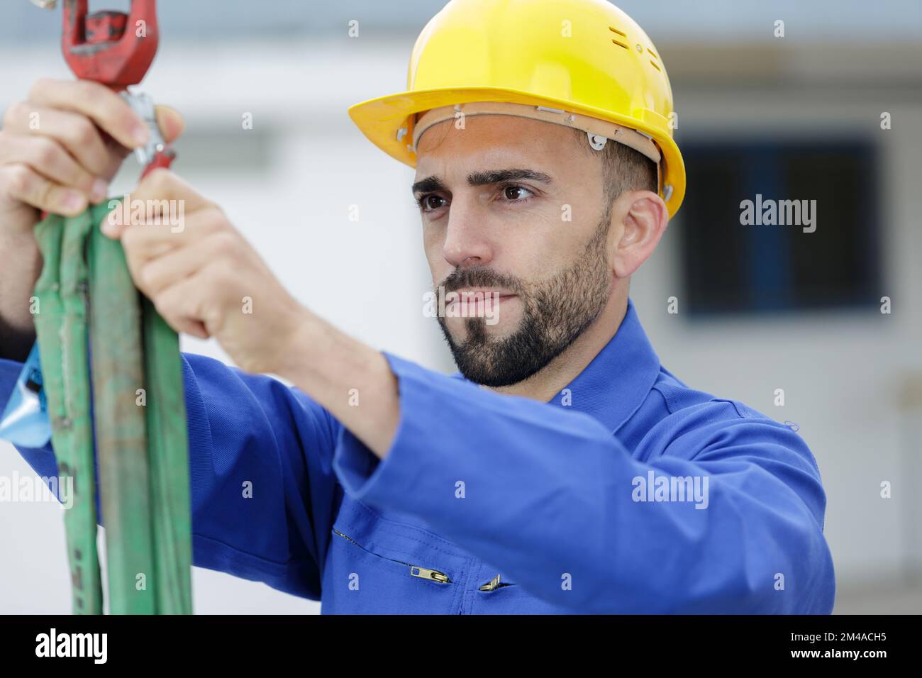 worker holding a hook for work on a container Stock Photo - Alamy