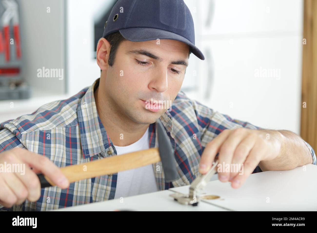 man focused on fixing cupboard hinges Stock Photo - Alamy