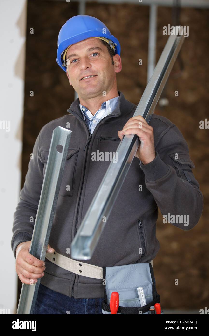 construction worker on site holding pipe Stock Photo - Alamy