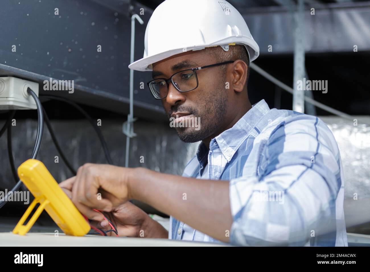 electrician using multimeter in ceiling Stock Photo - Alamy
