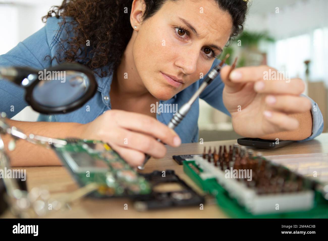 female worker choosing the correct attachment for tool Stock Photo - Alamy