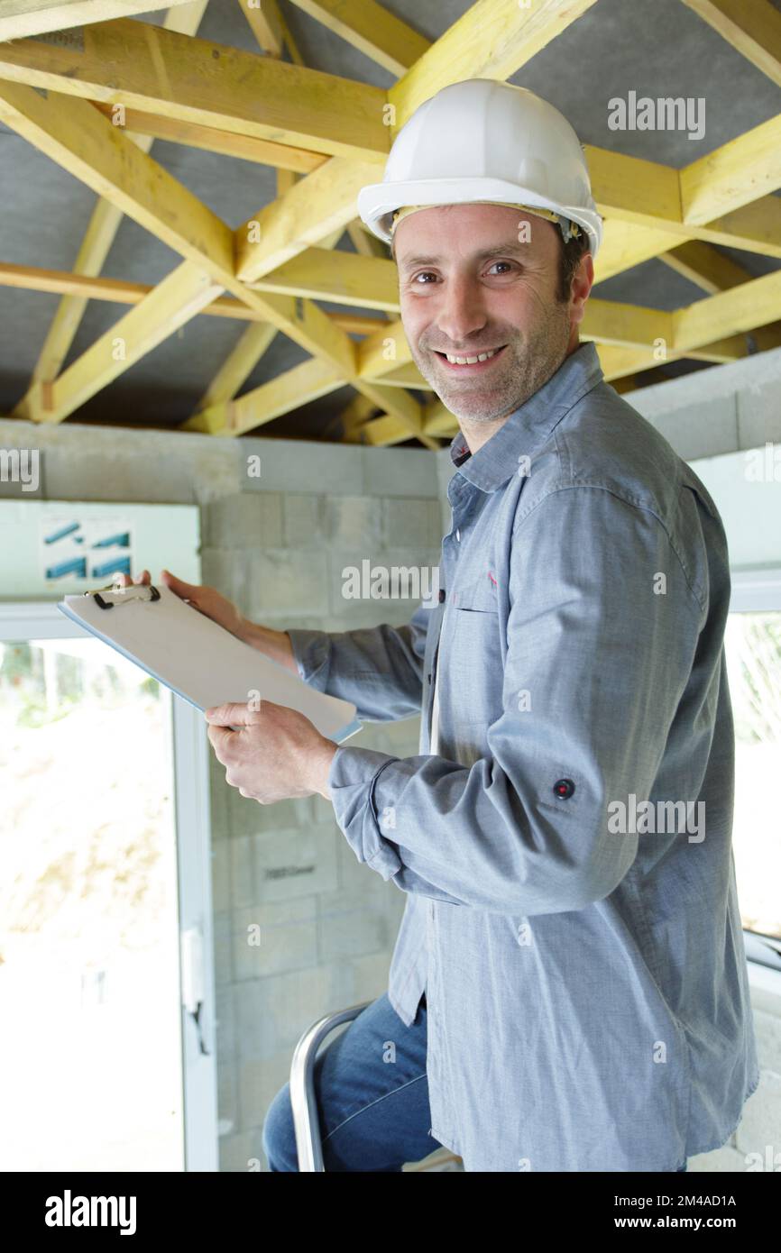man standing on ladder and working on house extension Stock Photo - Alamy