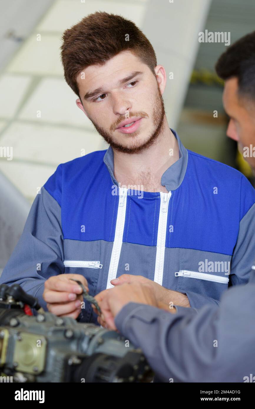 apprentice mechanic in auto shop working on car engine Stock Photo - Alamy