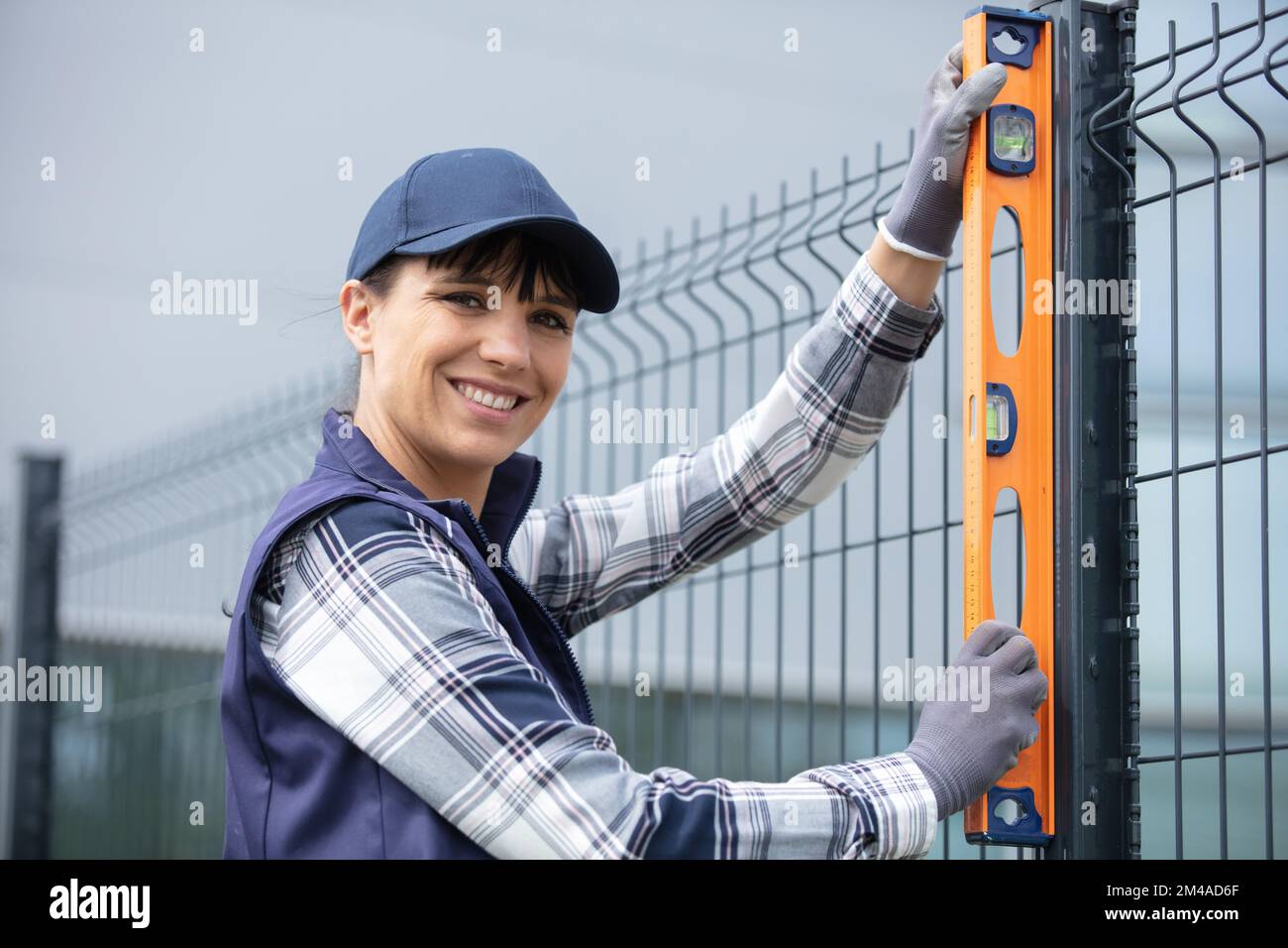 woman building metal fence checking with spirit level Stock Photo - Alamy woman building metal fence checking with spirit level Stock Photo - Alamy