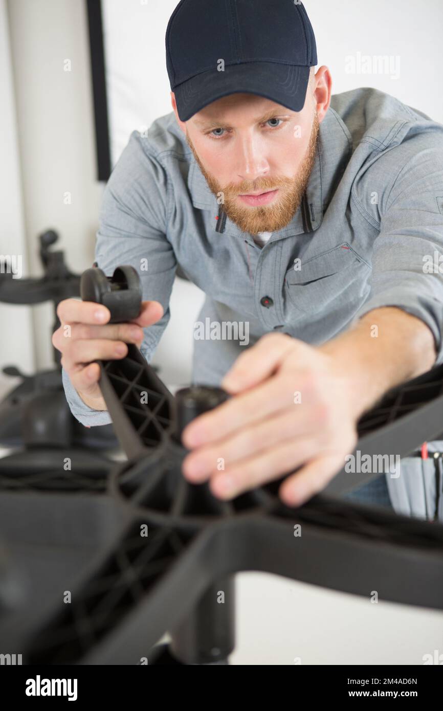 man fixing caster roller wheel of a wheel Stock Photo - Alamy