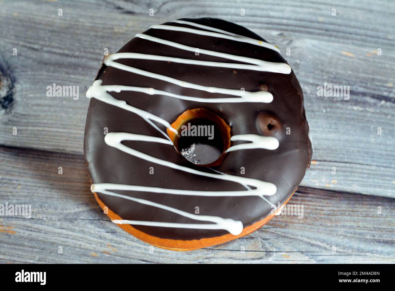 Brown chocolate ring donut with white chocolate sauce, A glazed, yeast ...