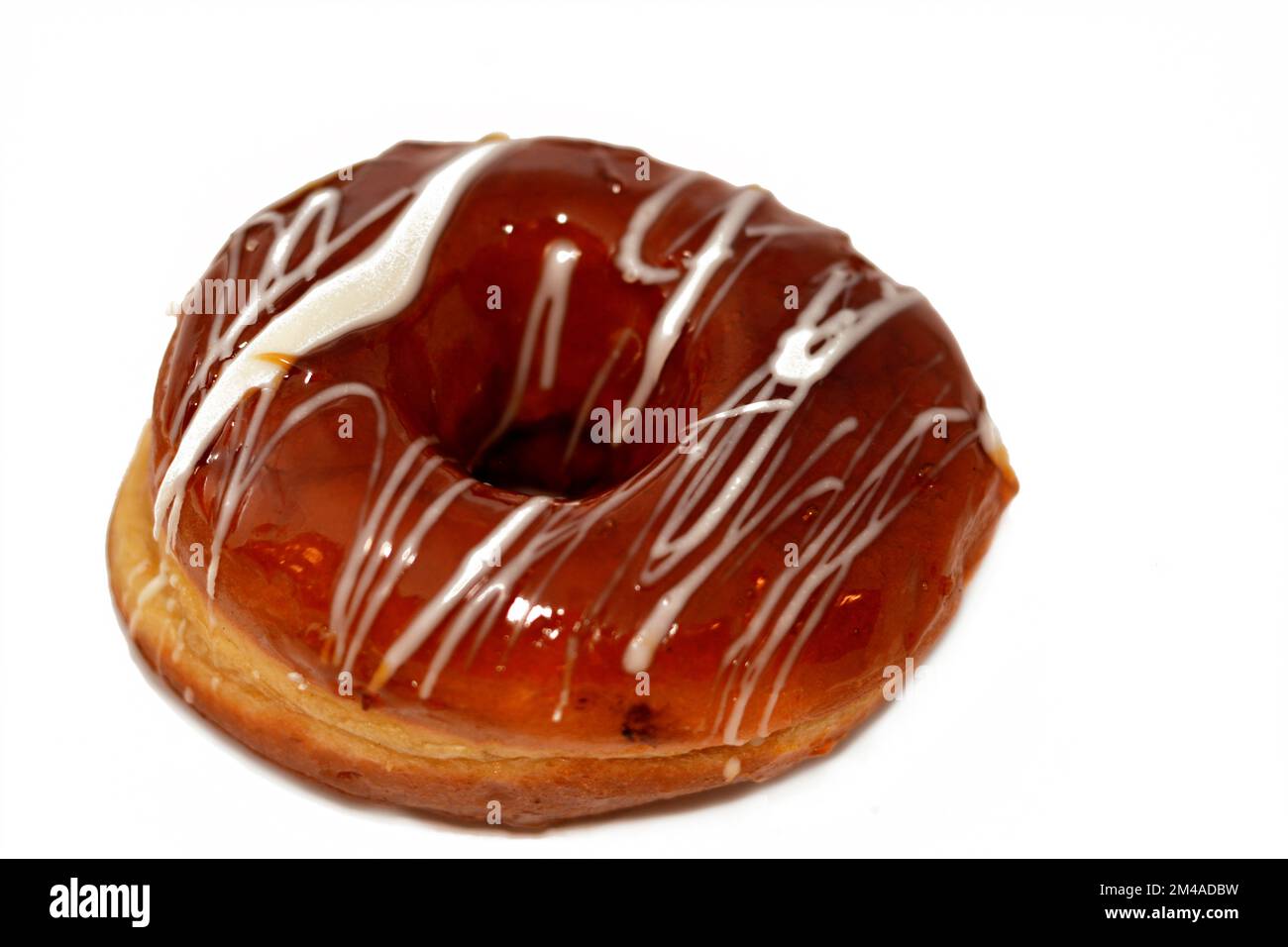 A ring donut topped with caramel and white chocolate sauce, A glazed ...