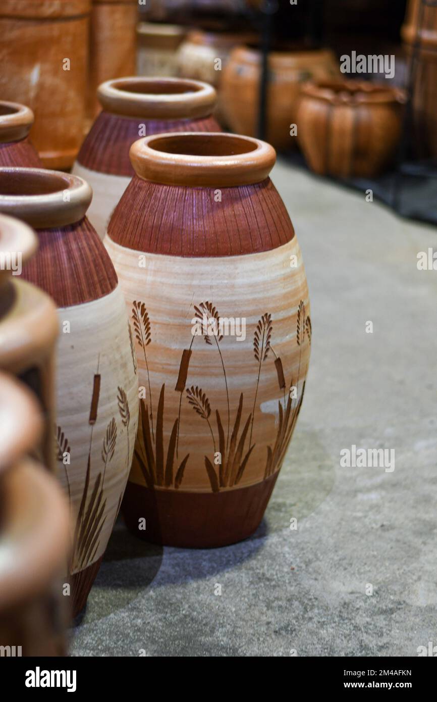 A vertical close-up of a clay pots with beautiful hand-painted patterns ...