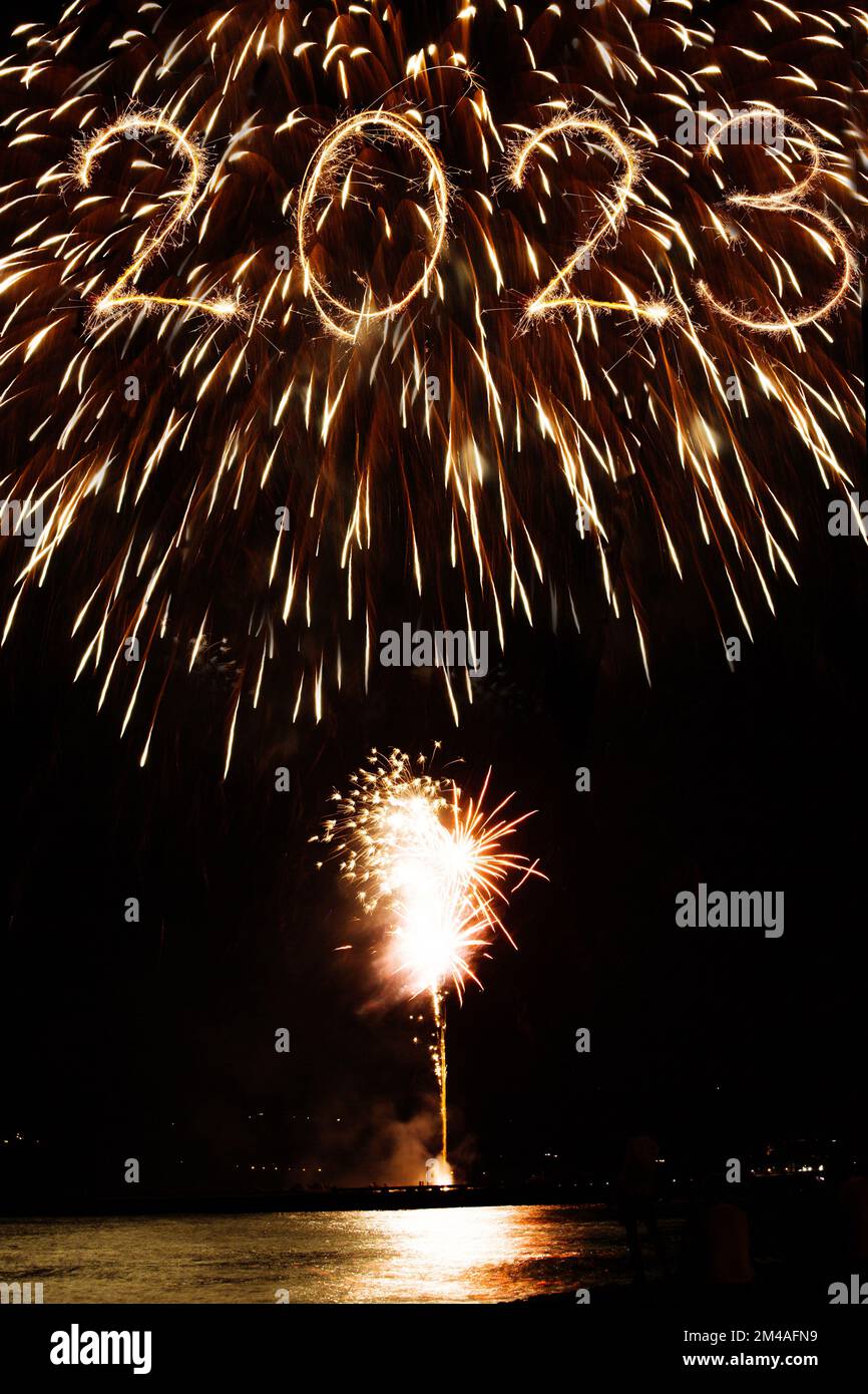 2023 new year coming written with sparkler and fireworks illuminationas ...