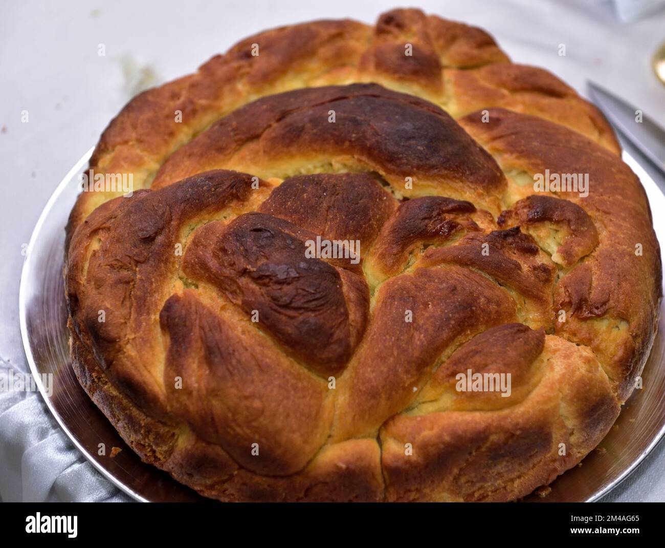 A top view of Pogacha bread with a knife on a white table Stock Photo ...