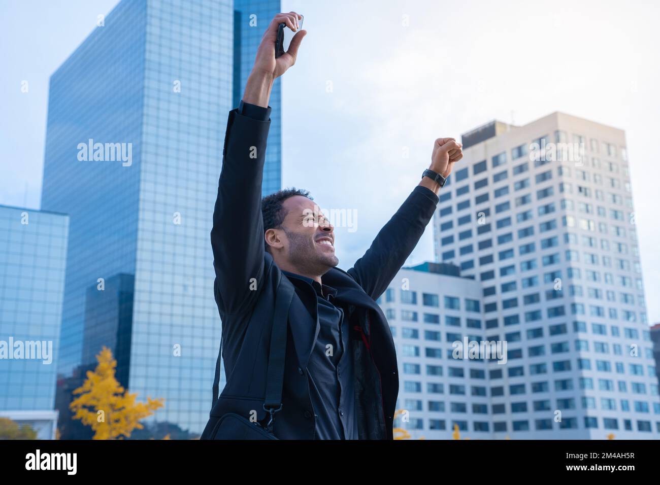 Successful African American businessman in suit raised arms smiling ...