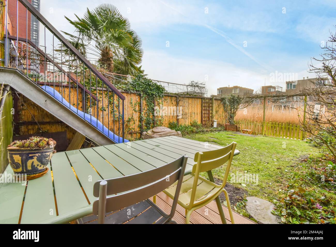 The backyard of a modern house with a seating area and a green lawn ...