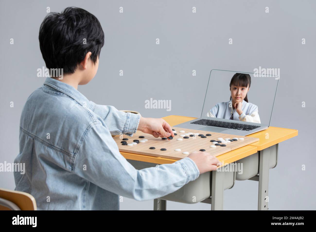 Chinese boy and girl playing the game of Go with laptop Stock Photo - Alamy