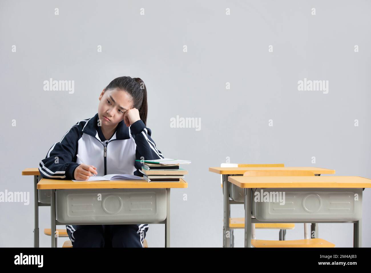 Chinese student thinking in classroom Stock Photo - Alamy
