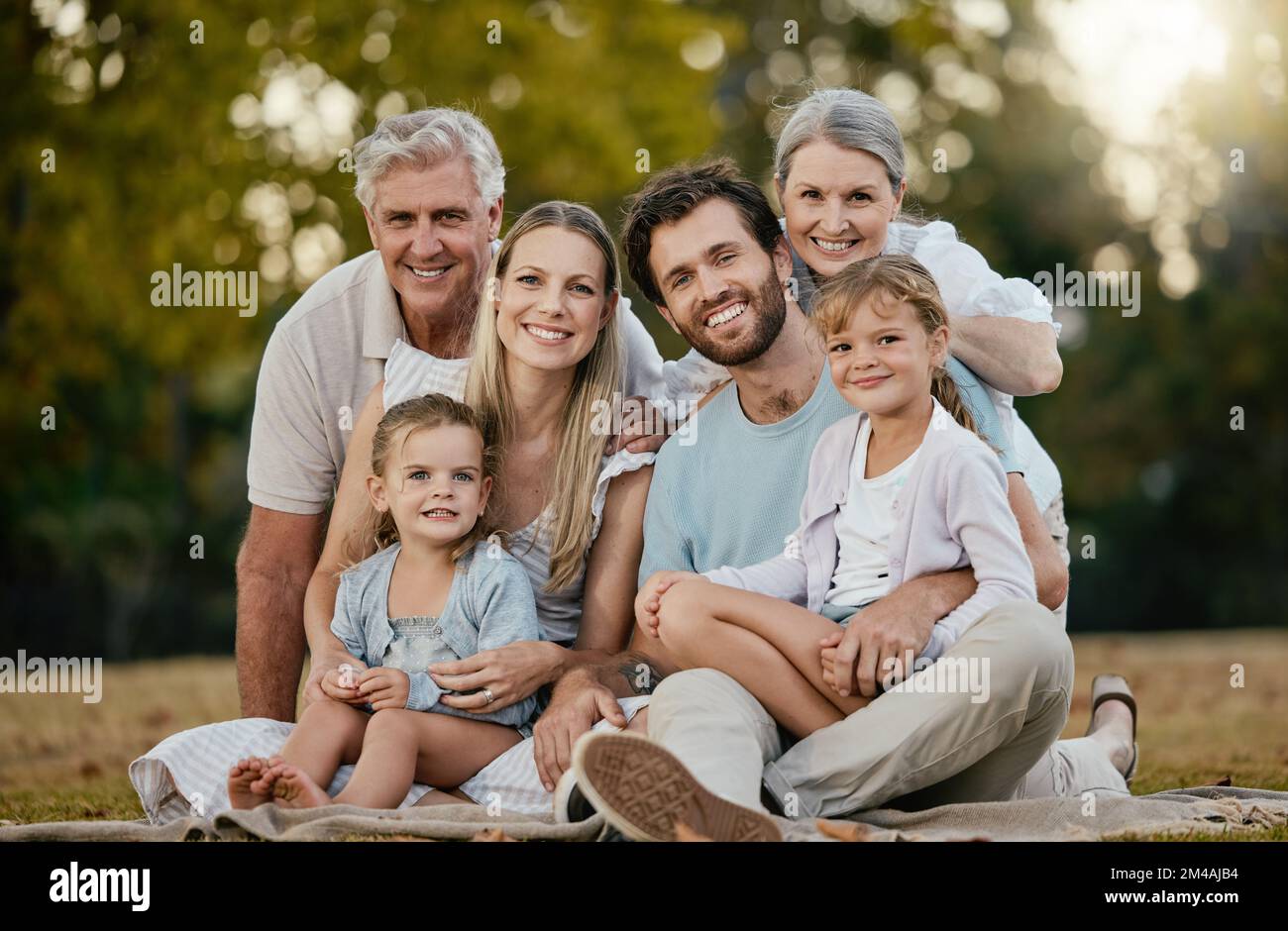 Family picnic, park portrait and smile with kids, parents or grandparents for bonding together ...