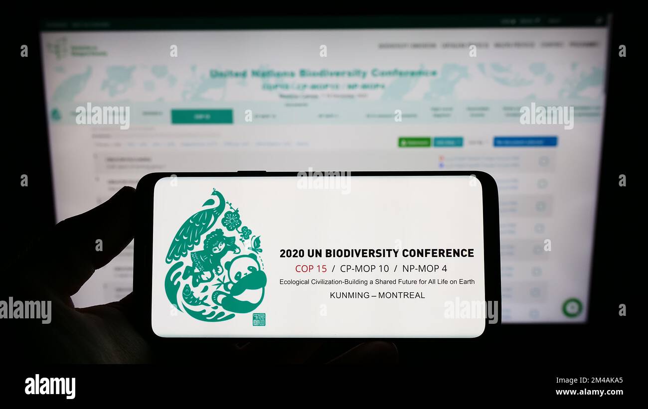 Person holding smartphone with logo of biodiversity conference CBD COP ...