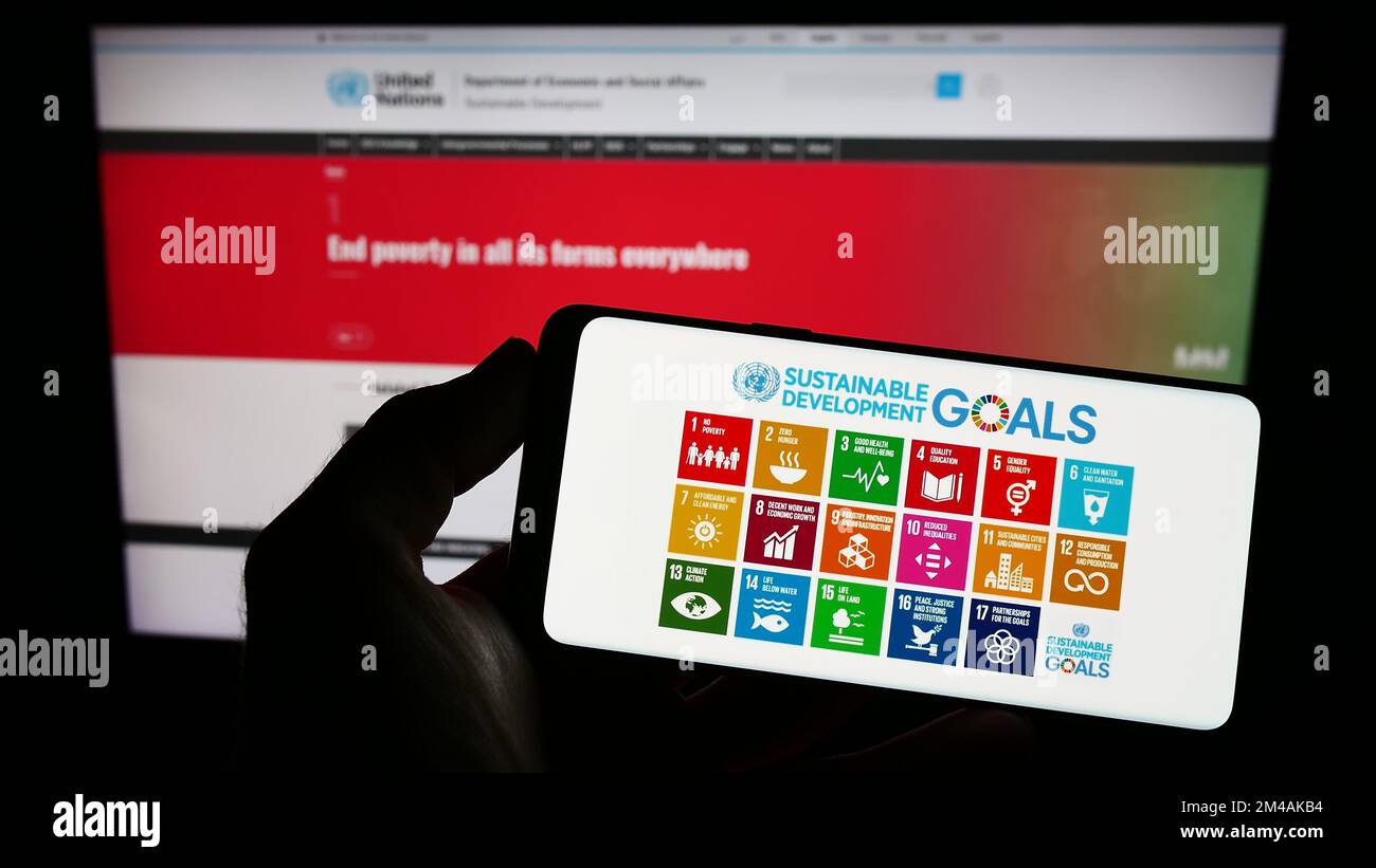 Person holding mobile phone with logo of UN Sustainable Development ...