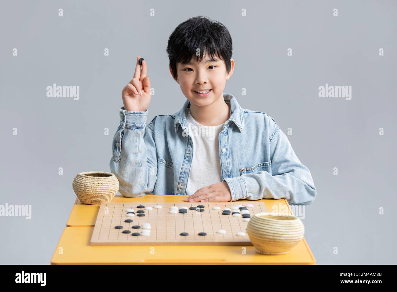 Cheerful Chinese boy playing the game of Go Stock Photo - Alamy