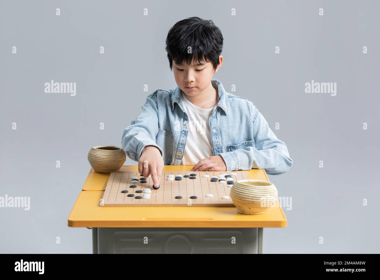 Cute Chinese boy playing the game of Go Stock Photo - Alamy