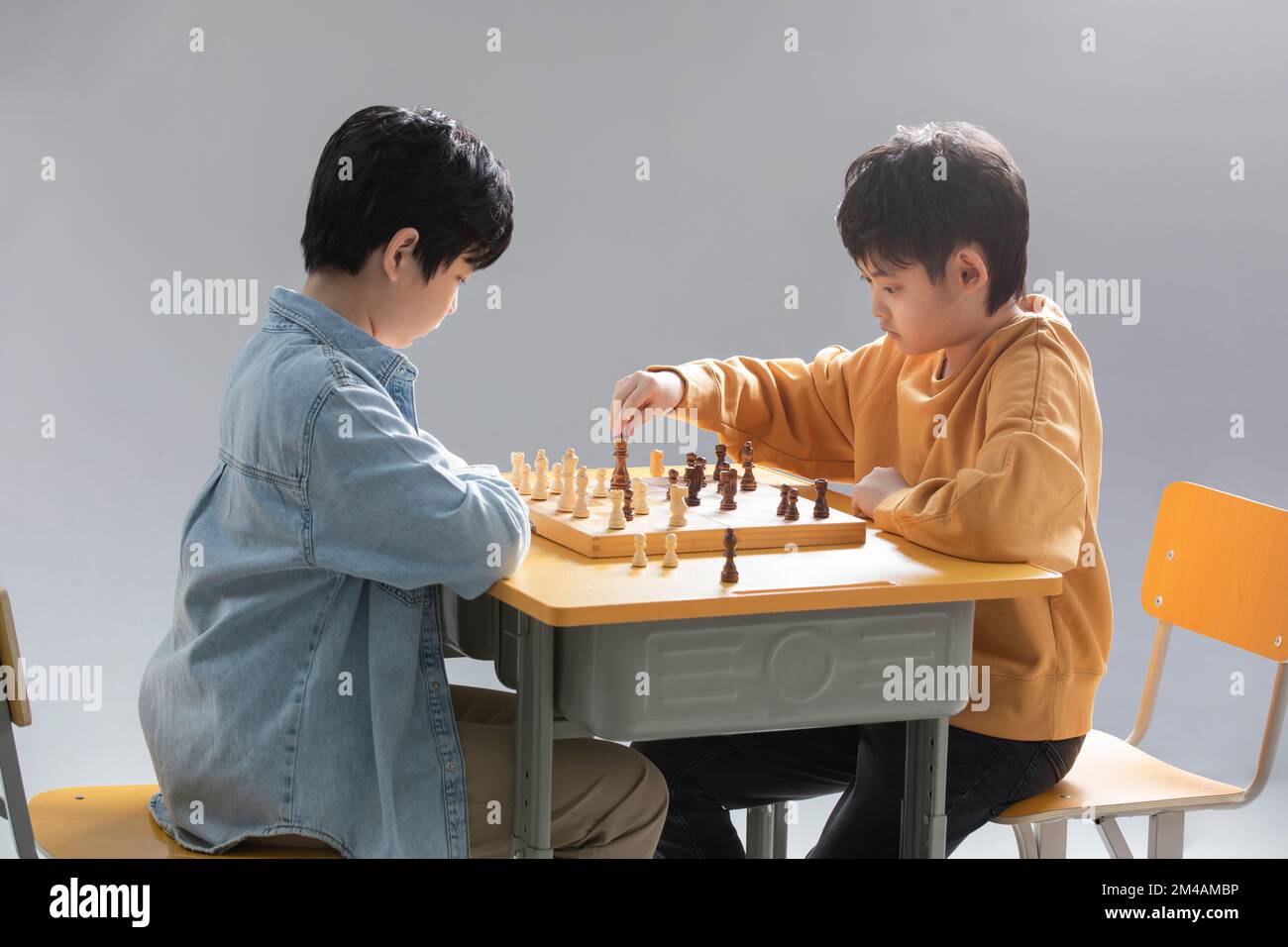 Two Chinese boys playing chess Stock Photo - Alamy