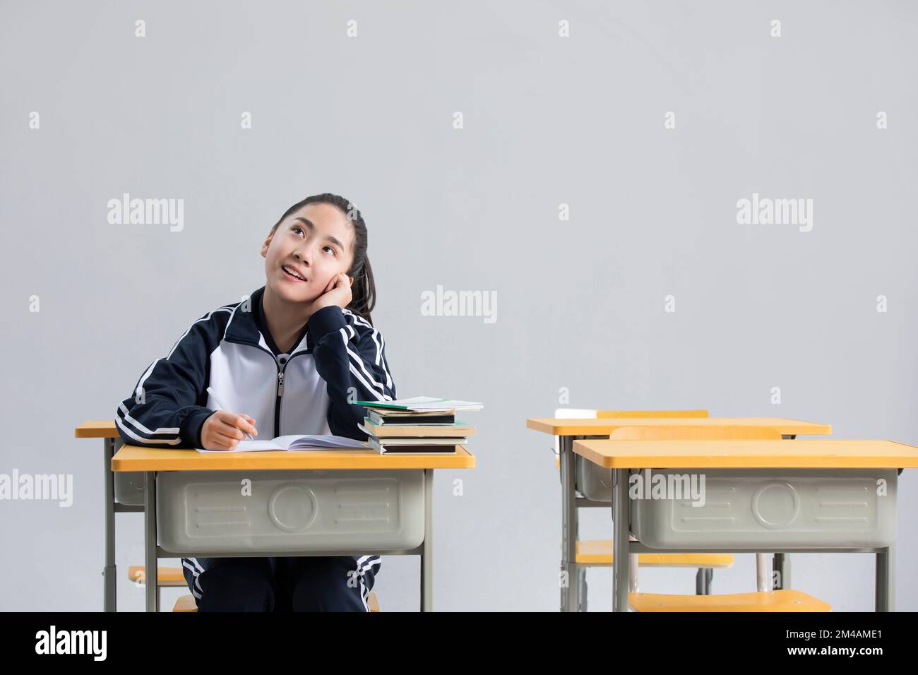 Chinese student thinking in classroom Stock Photo - Alamy