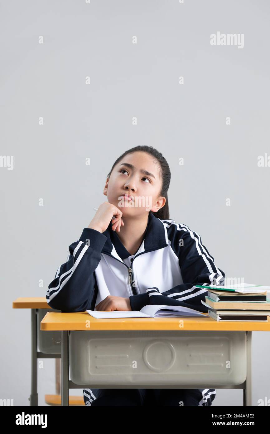 Chinese student thinking in classroom Stock Photo - Alamy