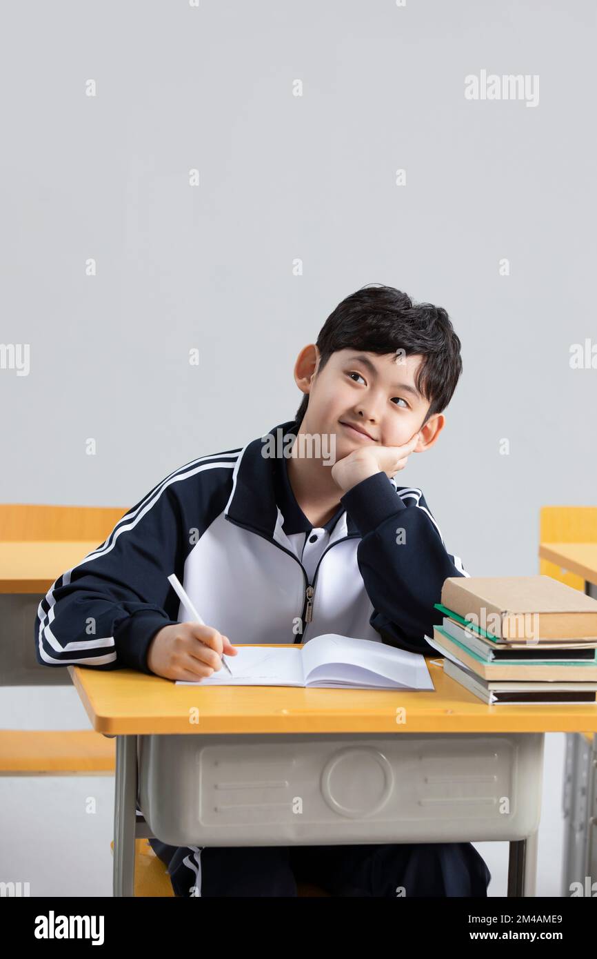 Chinese student thinking in classroom Stock Photo - Alamy
