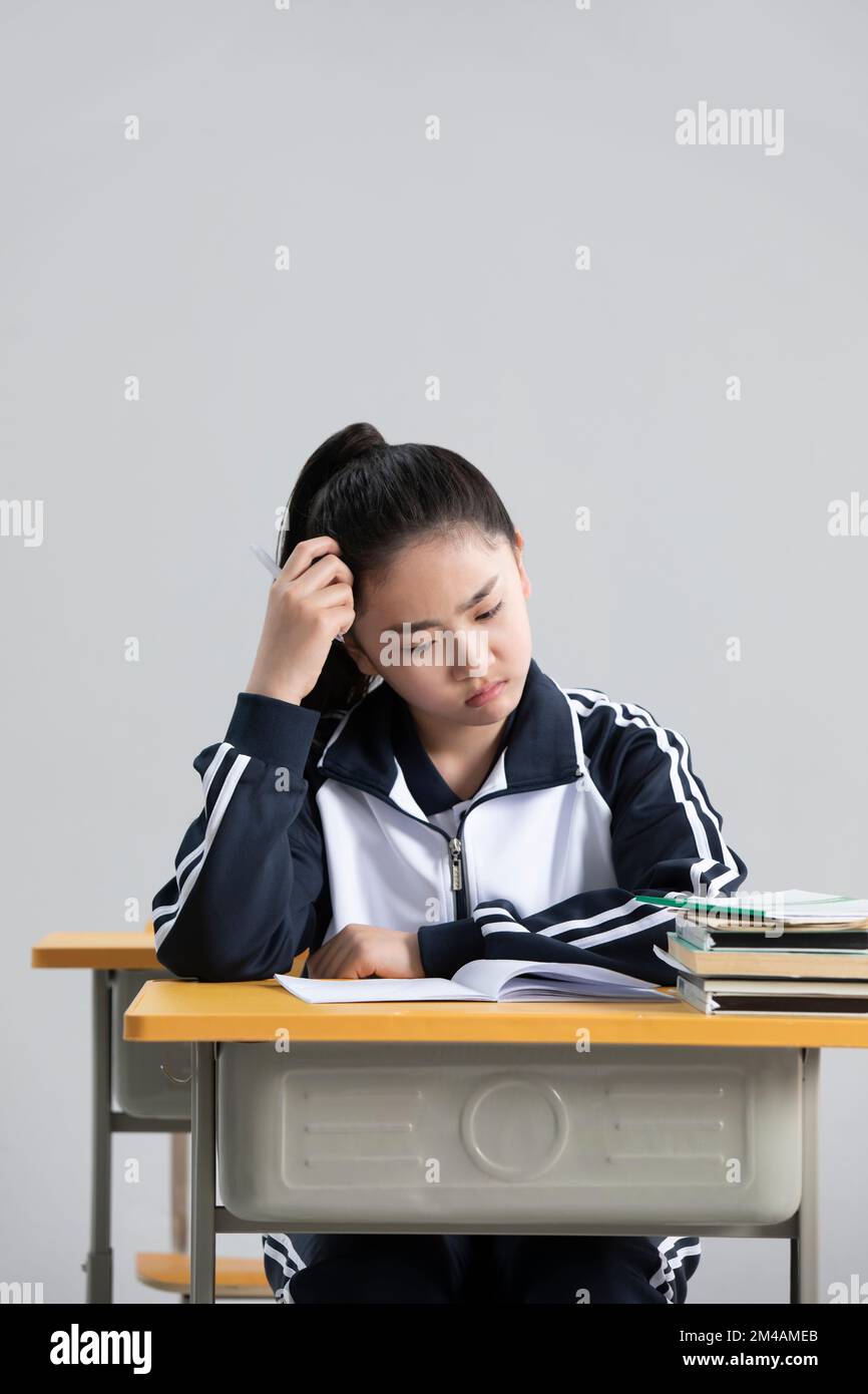 Chinese student thinking in classroom Stock Photo - Alamy