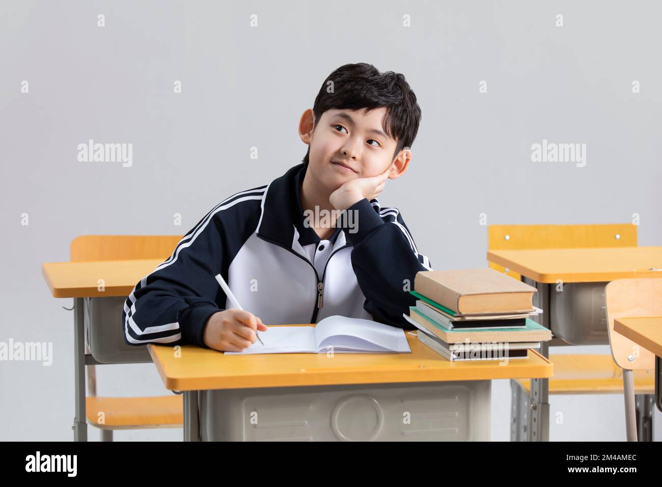 Chinese student thinking in classroom Stock Photo - Alamy