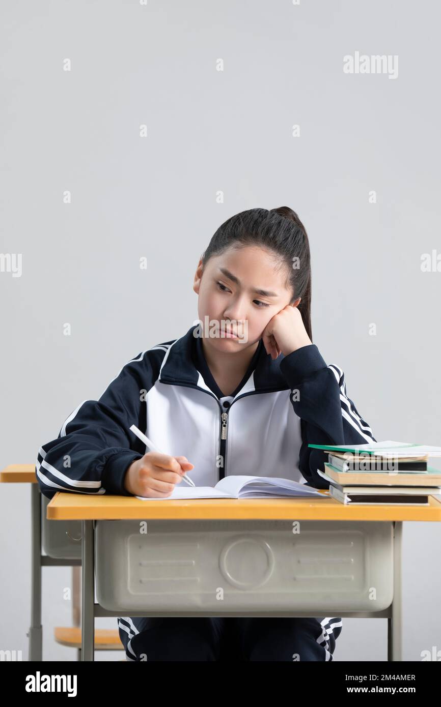 Chinese student thinking in classroom Stock Photo - Alamy