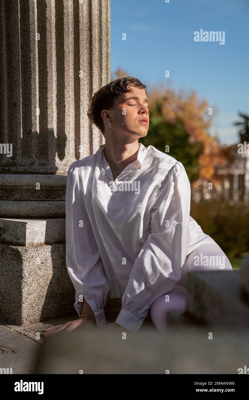 Dreamy young androgynous male millennial with short hair and makeup in ...